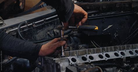 Crop Repairman Disassembling Engine Of Vehicle By Stocksy Contributor