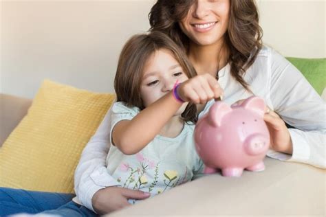 Premium Photo Mother And Daughter Putting Coins Into Piggy Bank