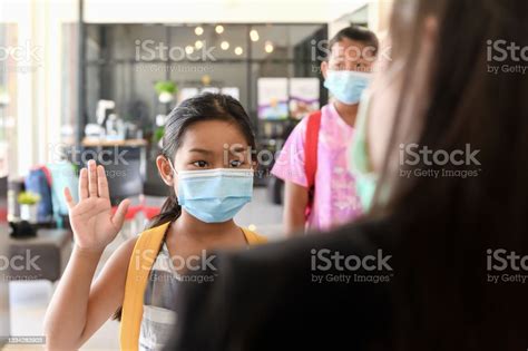 유치원 학생 소녀는 교사 사회적 상호 작용과 그녀의 손과 개인 정보 보고서를 제기 코로나바이러스 예방을 위한 교실에 들어가기