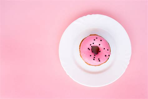 도넛 분홍색 설탕 프로 스 팅으로 덮여와 흰 접시에 검은 Roundels와 뿌 렸 다 0명에 대한 스톡 사진 및 기타 이미지 0명 끈적거리는 도넛 Istock