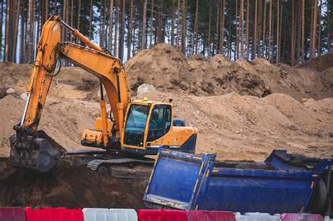 노란색 무거운 굴삭기와 불도저 는 모래를 발굴하고 도로 공사 중에 작업 새로운 도로의 건설 하는 동안 모래를 하역 교통수단에 대한 스톡 사진 및 기타 이미지 Istock