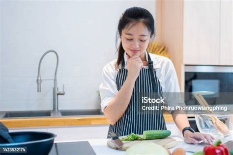 아름다운 아시아 여성의 초상화는 갈색 나무 부엌에 서 있습니다 가족을위한 다양한 과일과 채소로 구성됩니다 30 34세에 대한