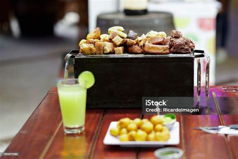 쇠고기 치카론 초리조 바나나 크리올 감자를 곁들인 접시와 레몬 주스를 나무 테이블에 얹은 프리탕가로 알려진 전형적인 콜롬비아 음식 콜롬비아에 대한 스톡 사진 및 기타 이미지