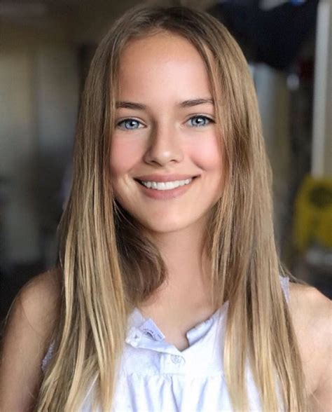 A Woman With Long Blonde Hair Smiling At The Camera