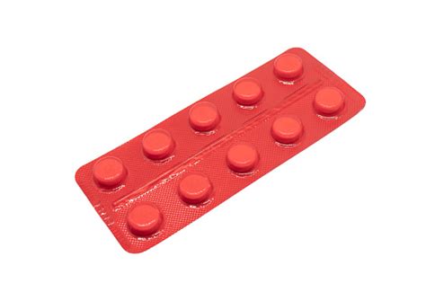 흰색 배경에 분리된 빨간색 물집 포장에 흰색 정제 알약의 매크로 샷 더미 알루미늄 호일 블리스터 팩 약국 제품 약과 마약 알약