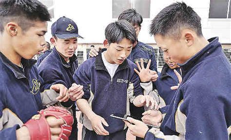 選抜高校野球抽選会 英明、勝利へ執着心 野球部のタブレットで組み合わせ抽選の結果を確認する英明ナイン＝英明高 四国新聞社