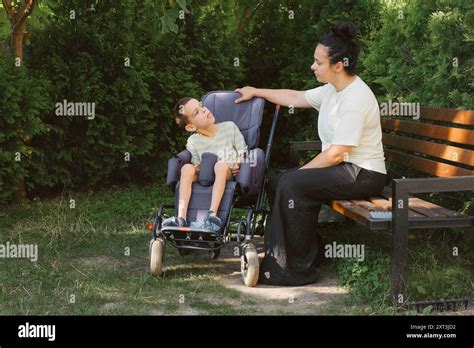 A Compassionate Mother Interacts With Her Son With Cerebral Palsy While