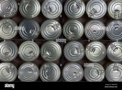 Food Behind Sheet Metal Lined Up Tin Cans With Pull Off Lids Viewed