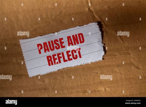 Pause And Reflect Message Written On Ripped Torn White Paper Piece With Cardboard Background