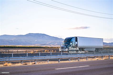 분할된 고속도로 도로에서 운전하는 냉동 세미 트레일러에서 화물을 운송하는 반짝이는 크롬 부품이 있는 블랙 보닛 대형 리그 세미 트럭 미국에 대한 스톡 사진 및 기타 이미지