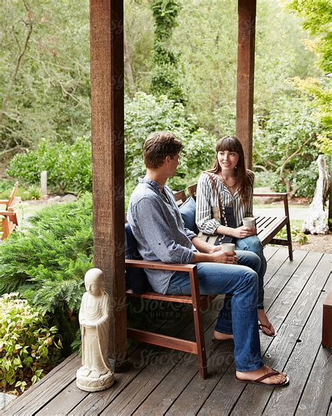 Couple Relaxing On Front Porch Drinking Tea At Day Spa By Stocksy