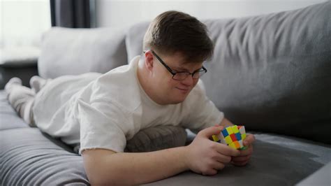 Premium Stock Video Down Syndrome Man Resting On The Couch At Home