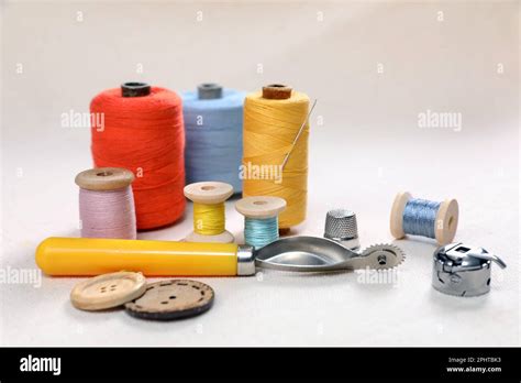 Color Threads Tracing Wheel And Other Sewing Accessories On White