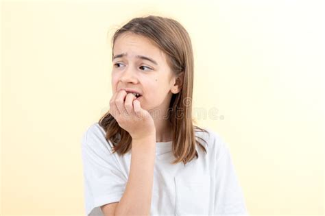 Scared And Anxious Girl Biting Her Fingernails On A White Background