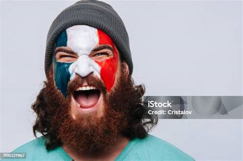 프랑스의 국기로 그려진 젊은 행복 수염 남자의 얼굴 축구 또는 축구 팀 팬 스포츠 이벤트 얼굴 아트와 애국심 개념 회색 배경에서