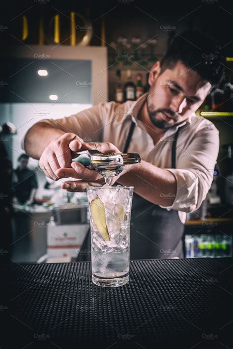 Bartender Making Cocktail Containing Cocktail Bar And Glass
