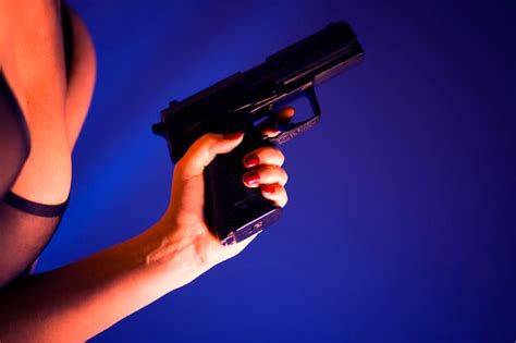 Premium Photo Midsection Of Woman Holding Gun Against Blue Background