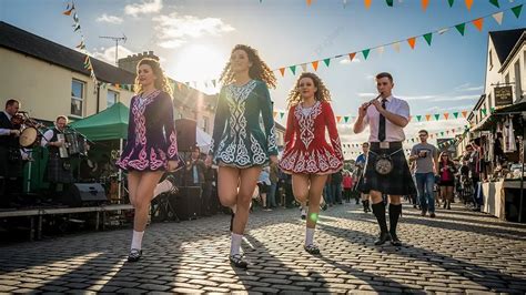 Three Irish Dancers In Traditional Dress Performing On Cobblestone