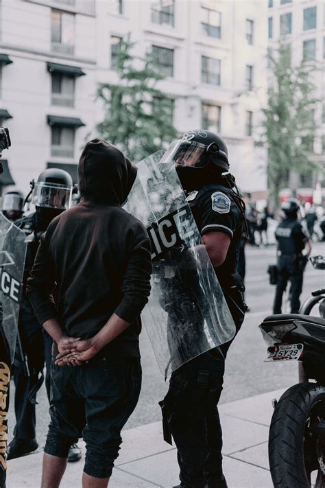Foto Hombre En Chaqueta Negra Sosteniendo Patineta Blanca Y Negra