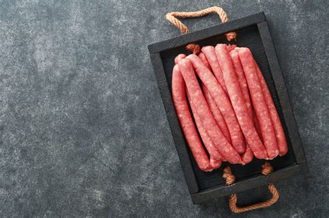 고기 쇠고기 소시지 검은 배경에 향신료 야채 및 요리 재료를 곁들인 생 바베큐 소시지 평면도 공간을 복사합니다 옥토버 페스트