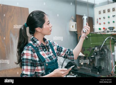 Pretty Elegant Milling Machine Company Female Worker Working With Mobile Smartphone And Looking