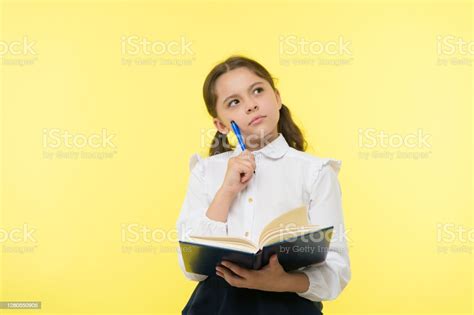 제복을 입은 소녀 귀여운 여학생은 책이나 교과서 노란색 배경을 가지고 있습니다 부지런한 학생은 책에서 지식을 얻습니다 아동복은