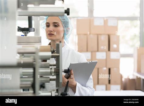 Female Manufacturing Supervisor Looking Worried While Checking Equipment And Production During