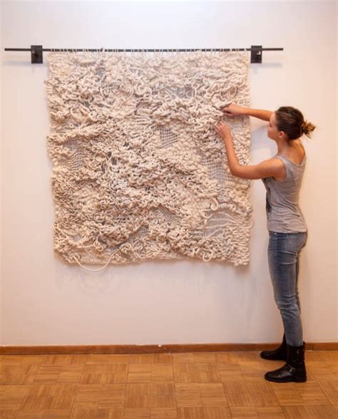 A Woman Standing In Front Of A White Wall Hanging On The Wall