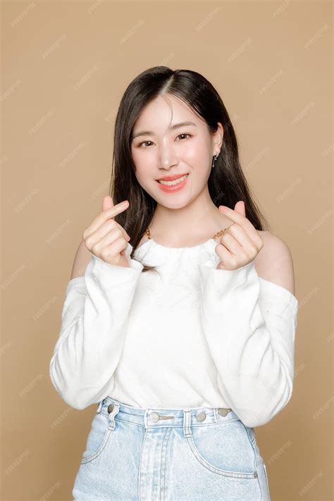 얼굴에 한국식 화장을 한 젊은 아시아 미녀 짧은 머리와 완벽하고 맑은 신선한 피부 쇼 외진 베이지색 배경 얼굴 치료 미용 성형