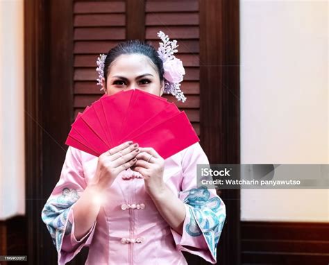 분홍색 드레스 중국 의상을 입고 있는 아름다운 여성 빨간 봉투를 손에 들고 행운의 표시 주변의 흐릿한 빛 렌즈 플레어 효과 개념에 대한 스톡 사진 및 기타 이미지 Istock