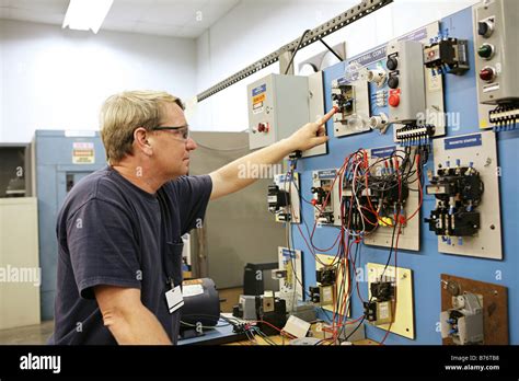 An Electrical Teacher Working On An Industrial Motor Control Center In
