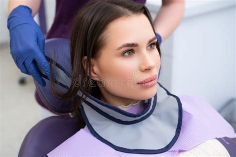 Dentist Outfits Patient With A Protective Neck Shield Before Commencing