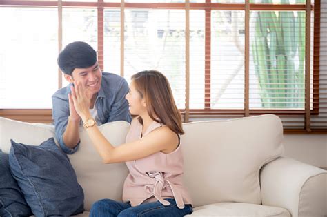 아름 다운 젊은 아시아 커플 남자와 여자 제스처 하이 파이브 함께 소파에 작업 성공 후 휴식 가족 축 하 즐길 수 있고 소파에