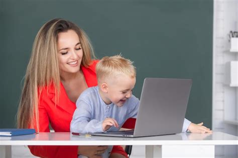 Madre e hijo juntos usando una computadora portátil pequeño hijo de la escuela usando una