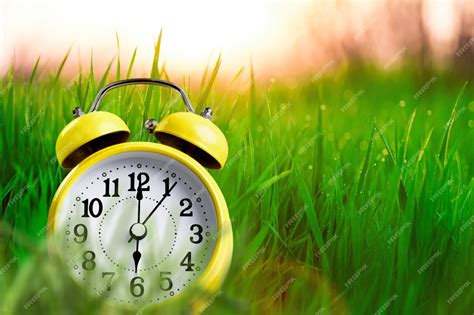 Premium Photo Classic Alarm Clock Over Spring Flowers Background