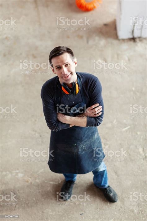 직장에서 카메라를 보고 교차 팔과 앞치마에 젊은 웃는 나무 노동자의 위의 보기에서 앞치마에 대한 스톡 사진 및 기타 이미지 앞치마 하이 앵글 남자 Istock