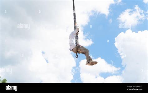 Worker Without Protective Gear Swinging On The Crane Chains Bad Example Of Work Safety