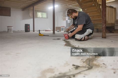 Basement Waterproofing Worker Sealing Cracks In Basement Floor To