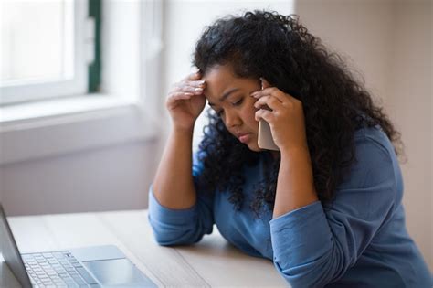 Premium Photo Upset Young Woman Sitting At Workdesk Working Online On