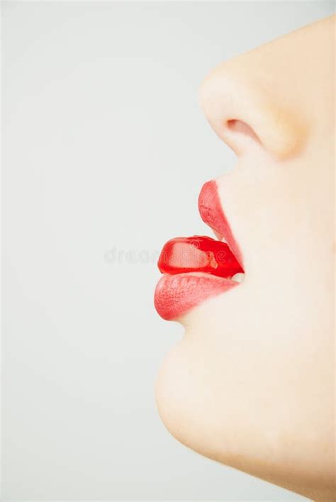 Orli Della Donna Che Mordono Una Gelatina Rossa Immagine Stock