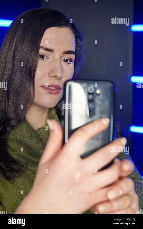 Girl Takes Selfie On Phone Against Background With Neon Lights Stock