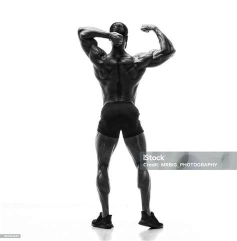 Black And White Image Of Strong Muscular Men Flexing Muscles From The