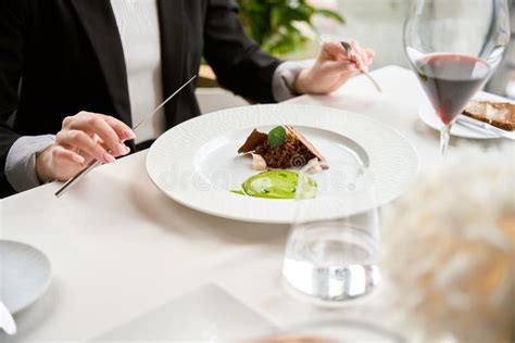 Young Man In Black Suit Tasting Salad In Luxury Restaurant Close Up