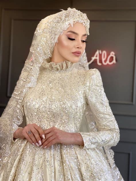A Woman In A White Wedding Dress With A Veil On Her Head And Wearing A Ring
