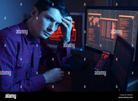 Male Hacker Thinking About The Problem Of Hacking Or Malware Infection On The Background Of