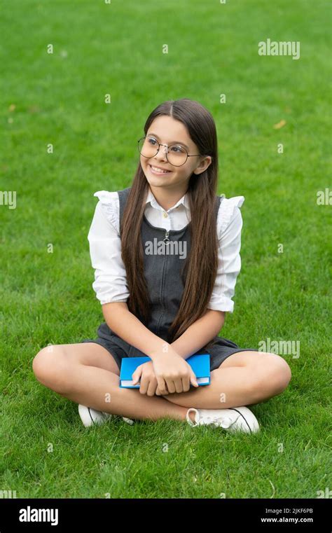 Happy Teen School Girl Sitting Legs Crossed On Grass School And