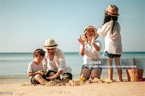 행복한 부모와 아이는 해변에서 여름 방학에 모래 놀이를 하며 즐거운 시간을 보내고 있습니다 여행 행복한 가족 및 휴가 개념