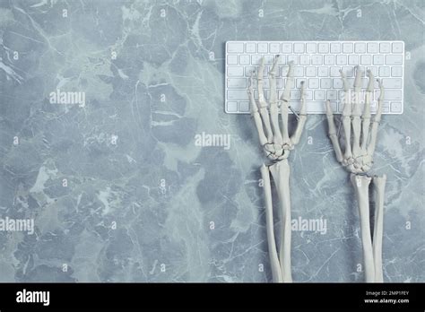 Human Skeleton Using Computer Keyboard At Grey Marble Table Top View