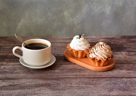 Two Shortbread Baskets And A Cup Of Hot Black Coffee On A Saucer With A Spoon On A Wooden Table
