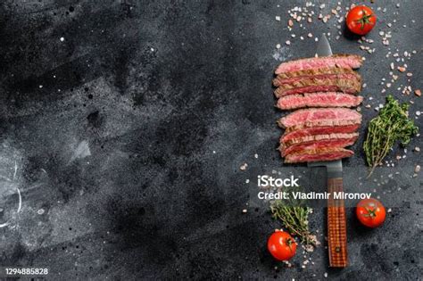 구운 슬라이스 플랫 아이언 희귀 스테이크 대리석 쇠고기 고기 검은 색 배경 맨 위 보기입니다 복사 공간 바비큐에 대한 스톡 사진